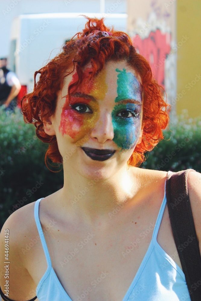 portrait of queer young woman smiling with lgbtqia rainbow pride flag ...