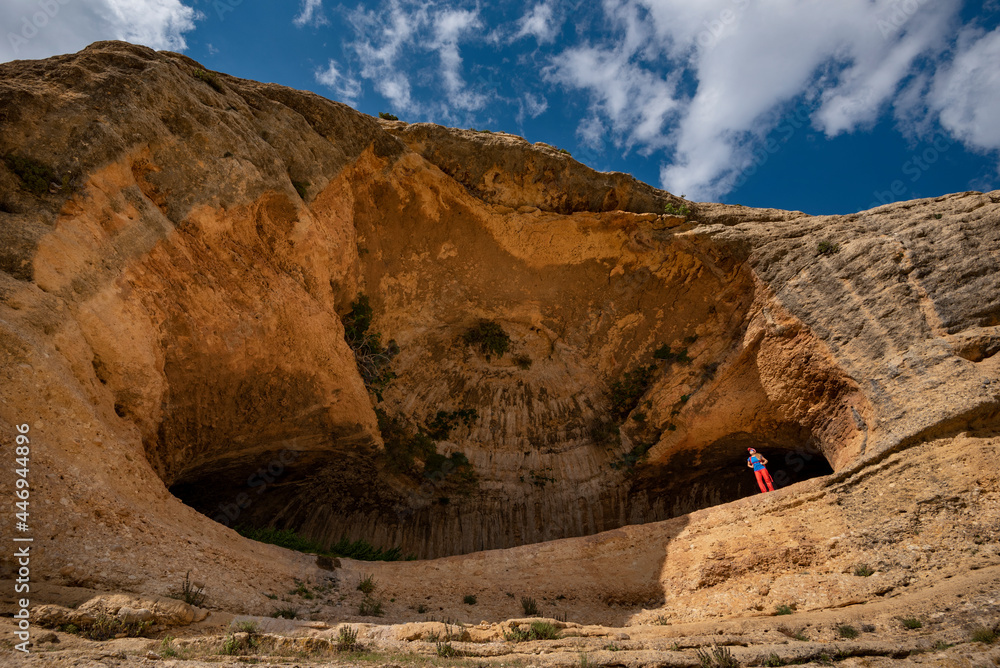 A women hiking a scenic trail under a giant overhang Caves of Zaen ...