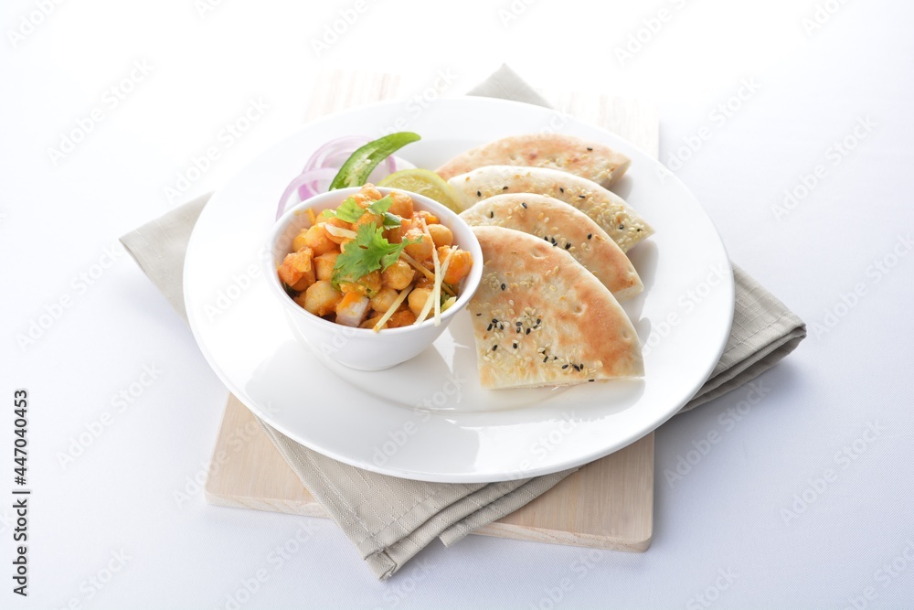 Indian vegetable bean curry with baked naan pizza bread in white ...