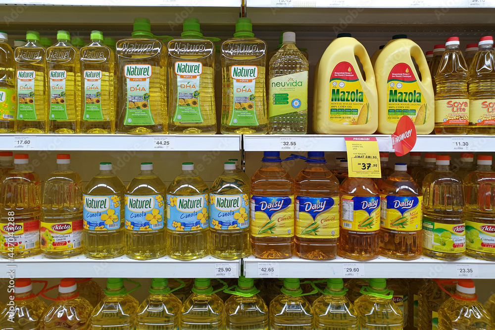 Rows of various brands healthy cooking oil display on store shelf in ...