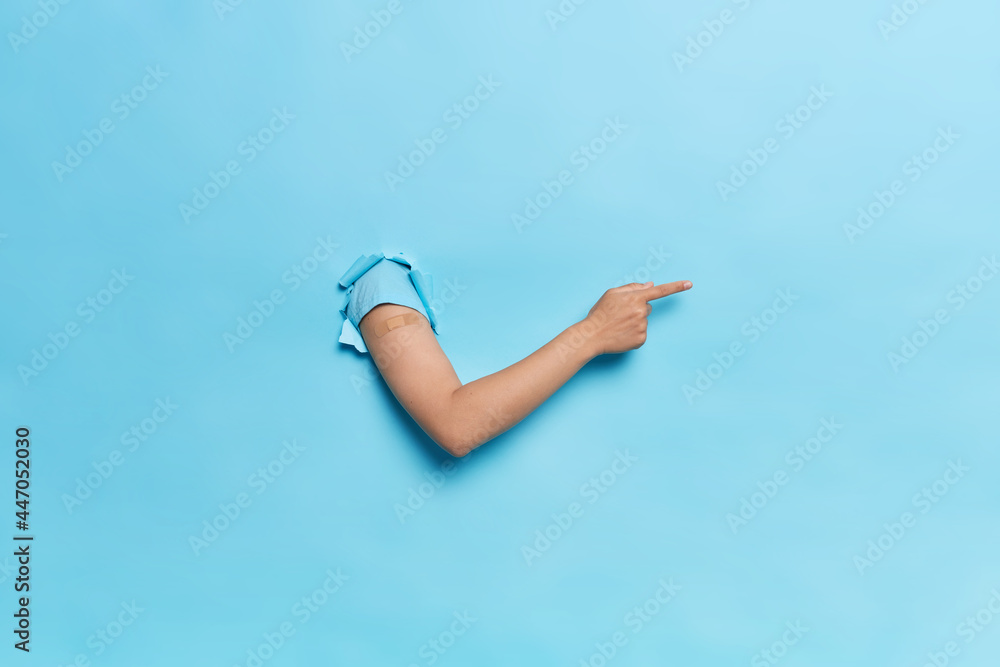 Horizontal shot of unknown person breaks arm through paper background ...
