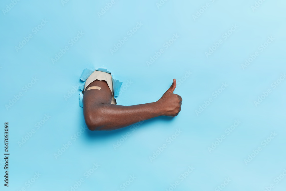 Dark skinned human shows vaccinated arm wears adhesive plaster after ...