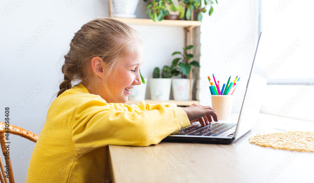 Caucasian cheerful school girl, typing on a laptop keyboard while ...