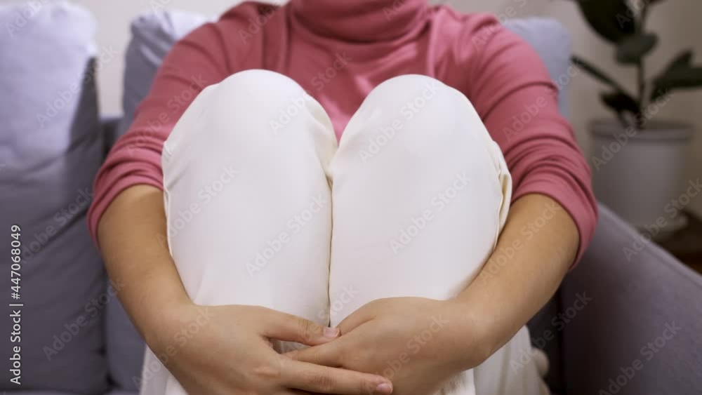 Nervous young woman hugging her legs, feeling insecure. Depressed and ...