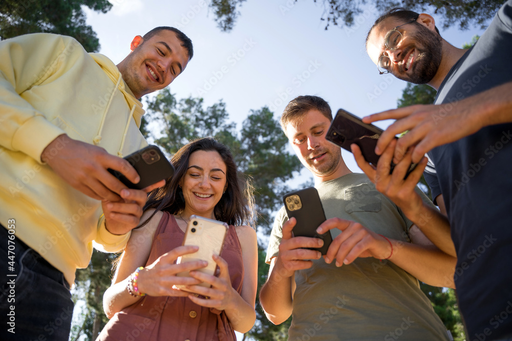 Friends smiling with their mobile phones. Each one with his mobile ...