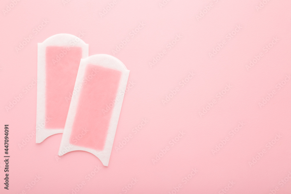 Two wax strips on light pink table background. Pastel color. Closeup ...