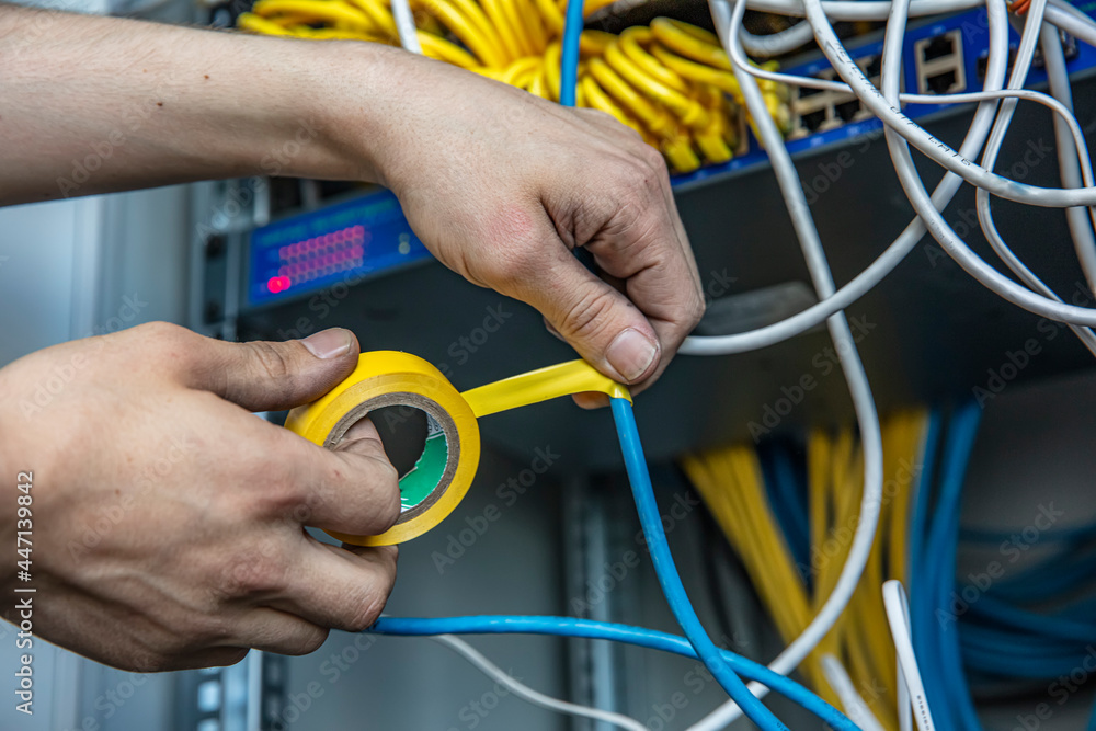 Electrician is repairing the wiring in the electrical room with ...