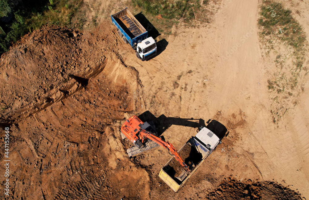 Excavator load the sand into dump truck. Aerial view of an backhoe on ...