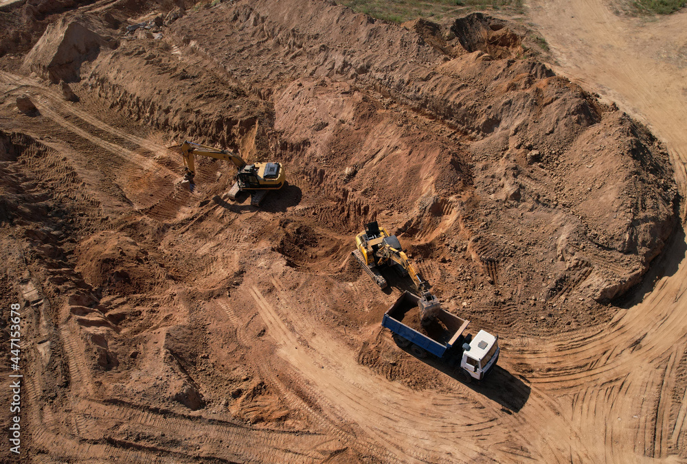 Excavator load the sand into dump truck. Aerial view of an backhoe on ...