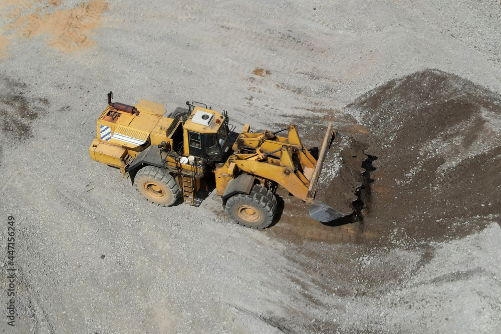 Wheel loader works in a gravel pit. Loading or unloading stone and ...