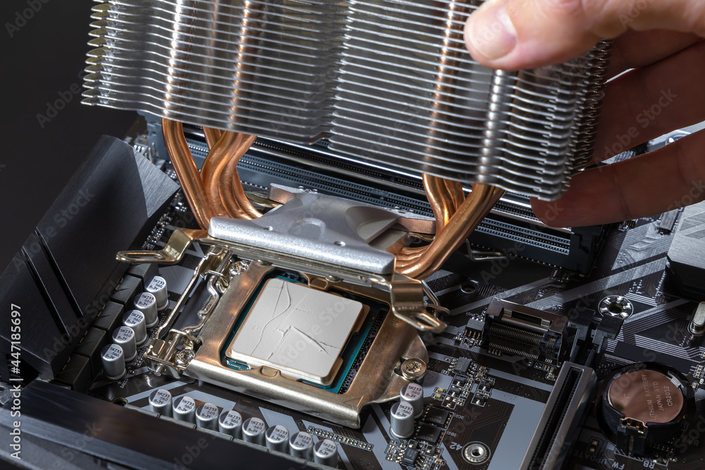A technician installs an aluminum air-cooled heatsink on a desktop PC ...