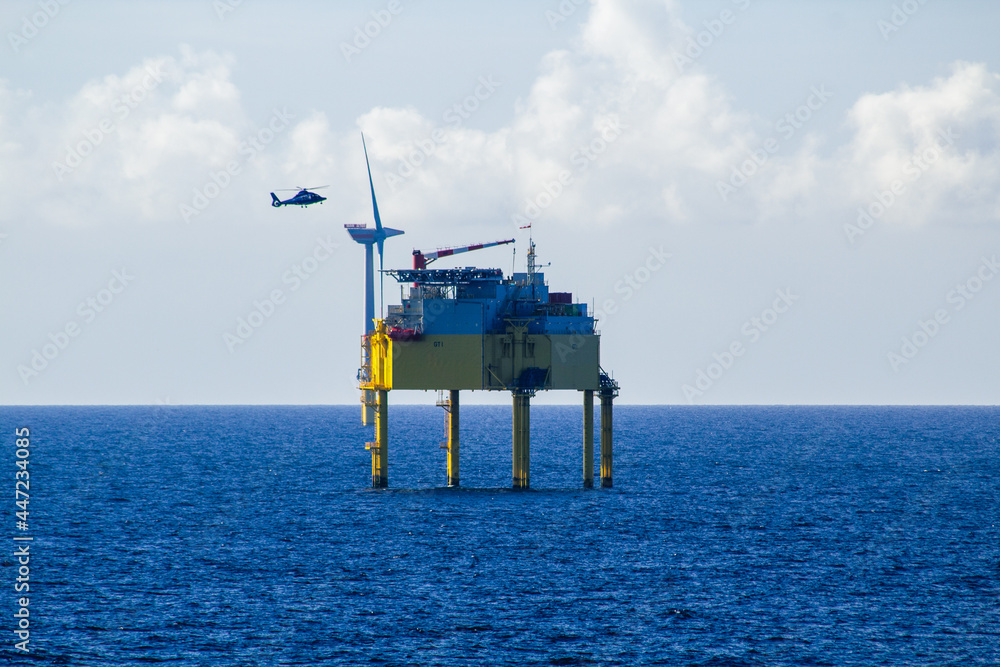 Helicopter approaching a transformer platform at an offshore wind farm ...