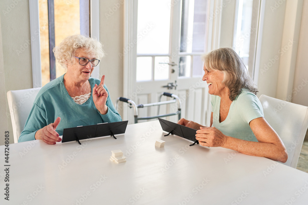 Two senior women are playing Rummikub for memory training Stock Photo ...