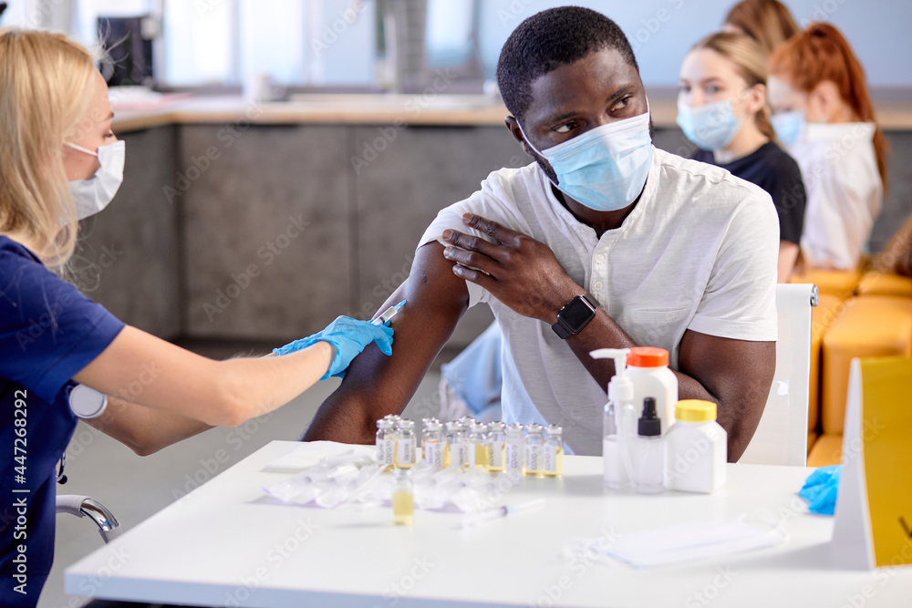 Mass vaccination and immunization. Professional female nurse giving an ...