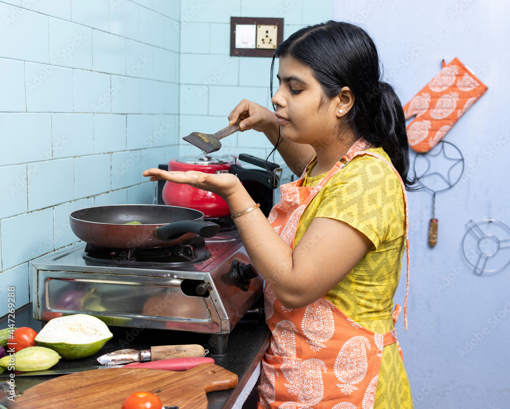 Indian housewife in kitchen Stock Photo | Adobe Stock