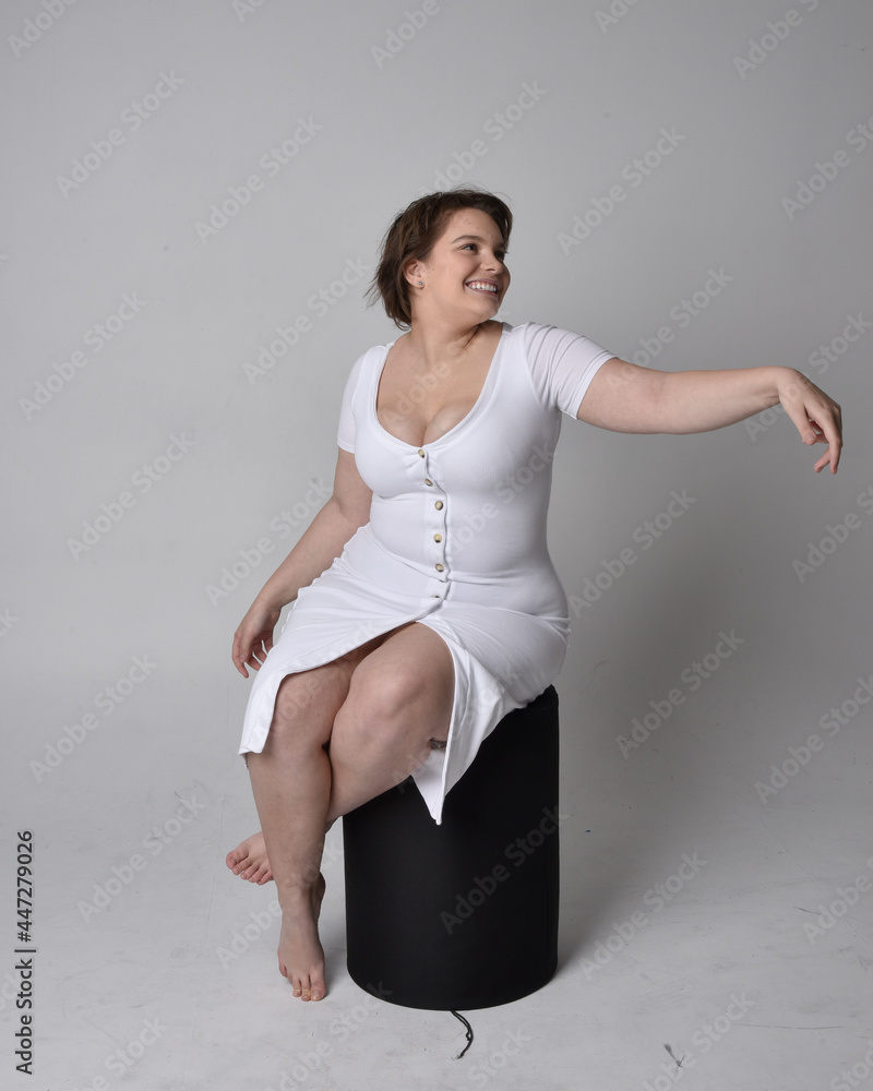 Full length portrait of young plus sized woman with short brunette hair ...
