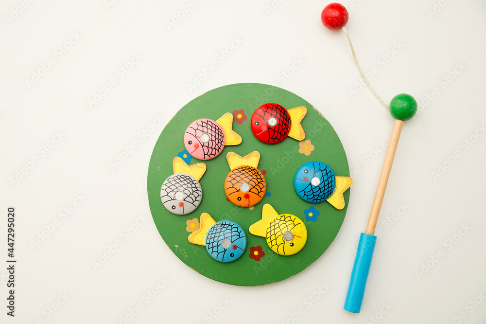 Let's go fishing. Wooden fishes and fishing rod with magnet on the tip ...