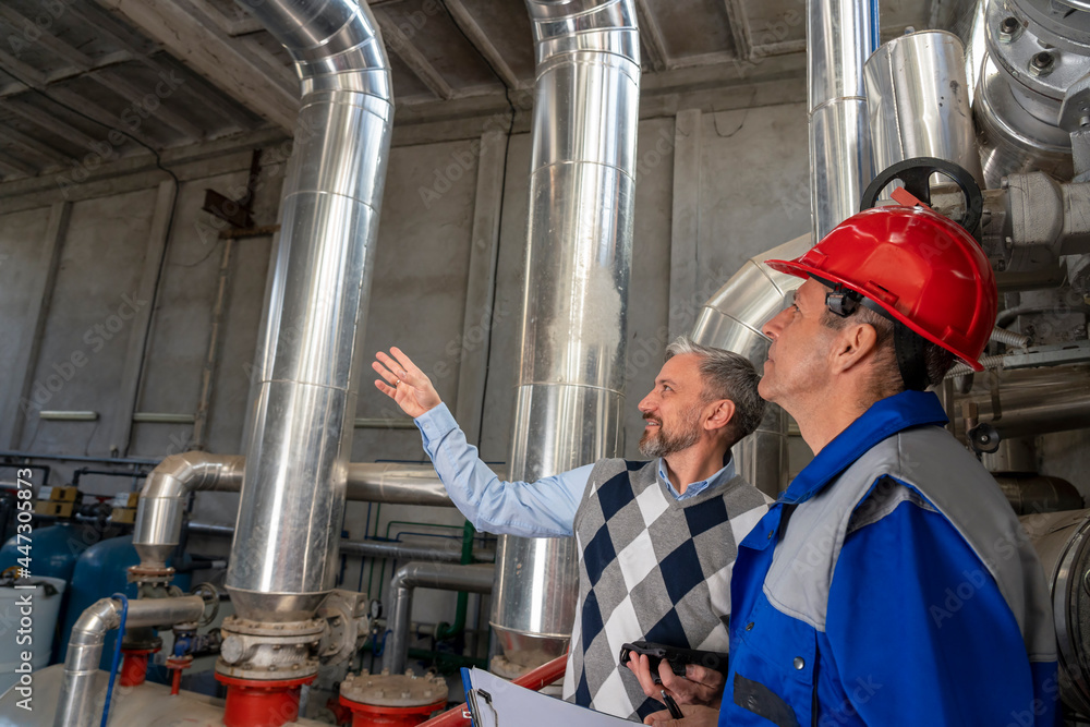 Technical Manager Standing Next to Worker and Pointing to Large Piping ...