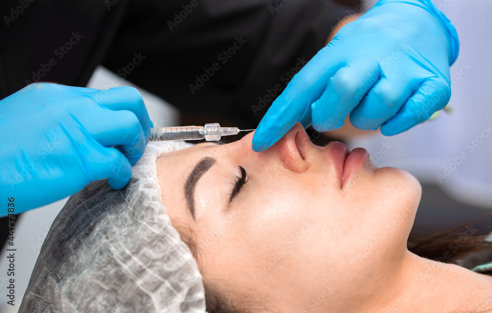 Cosmetic procedure for non-surgical rhinoplasty. The beautician inserts ...