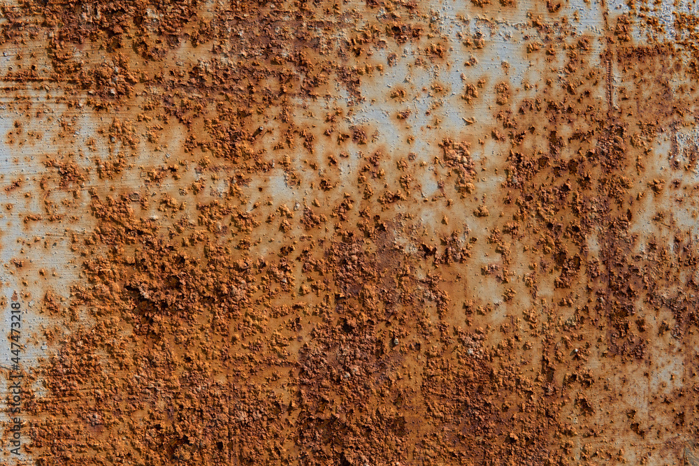 The rusty metal fence is covered with pimples. The aging process of ...