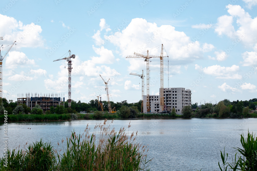 Construction cranes and building on construction site with cloudy blue ...