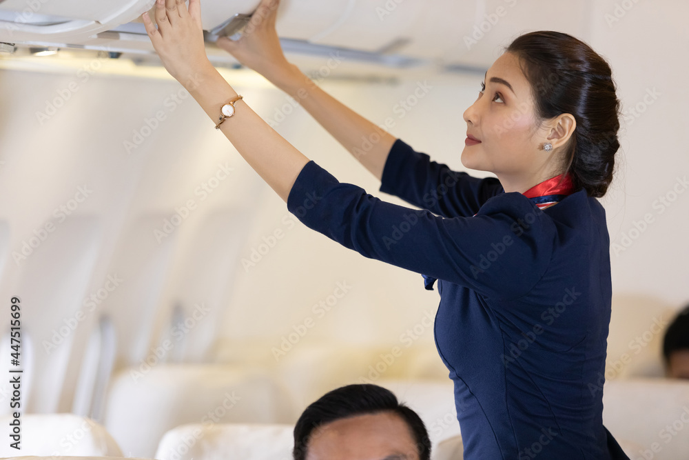 flight attendant checking and closing cabin compartment in airplane ...