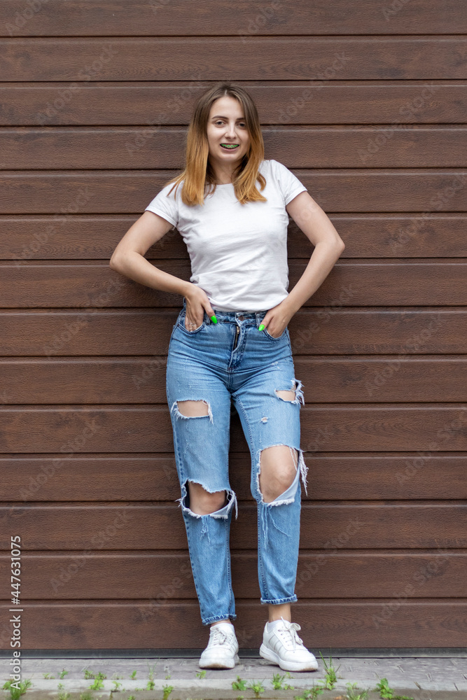Full height portrait of a young woman in casual clothing on brown ...