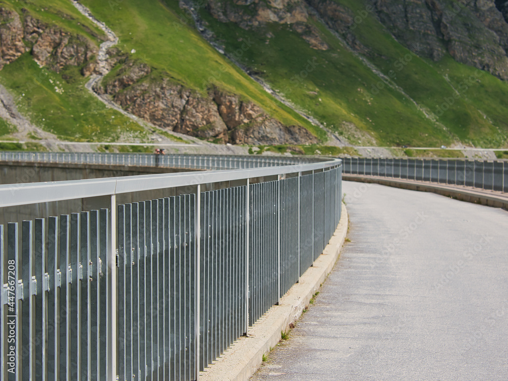 View of a single lane road in a curve, with railings at the roadside ...
