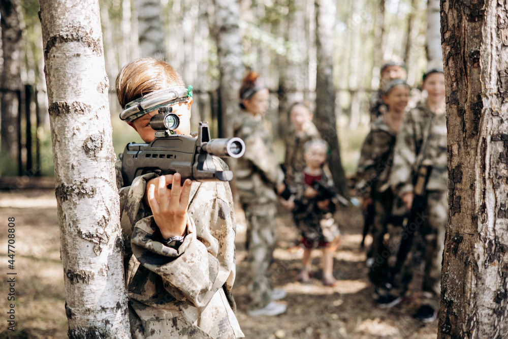 Boy looking into the optical sight a weapon. Children playing laser tag ...