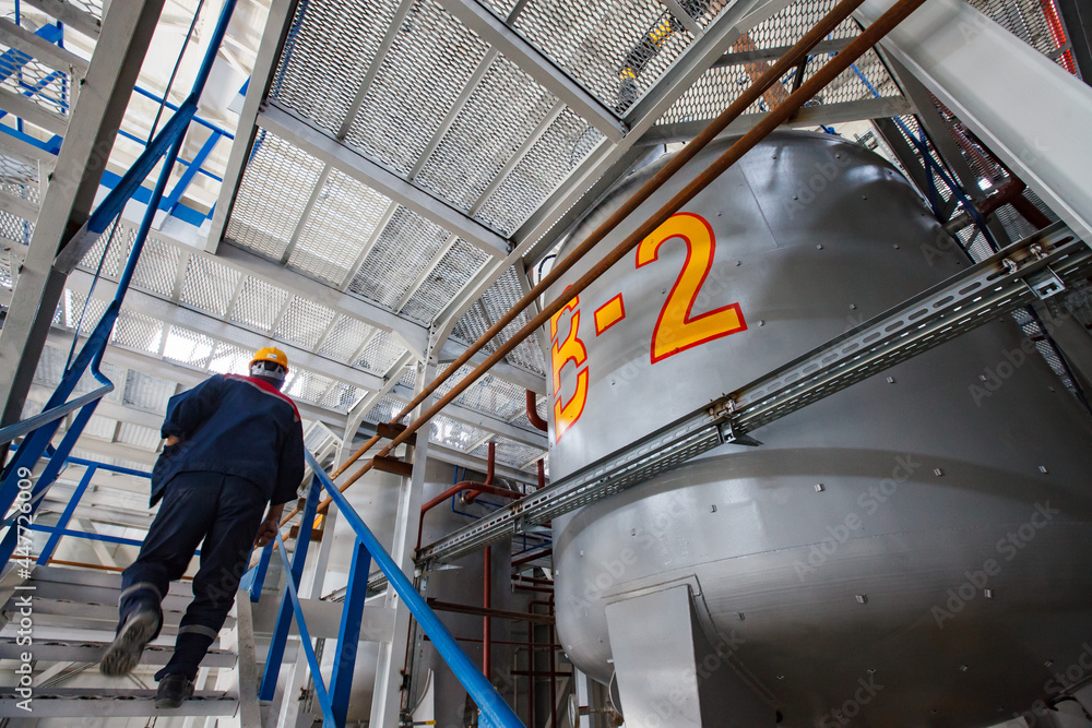 Rauan Nalco chemical plant. Grey steel tank of chemical reactor, grid ...