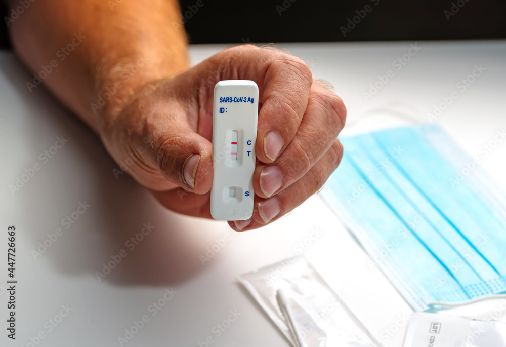 An infected man showing positive test's result on covid19 selftest kits ...