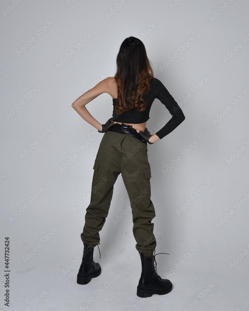 Full length portrait of pretty brunette, asian girl wearing black top ...