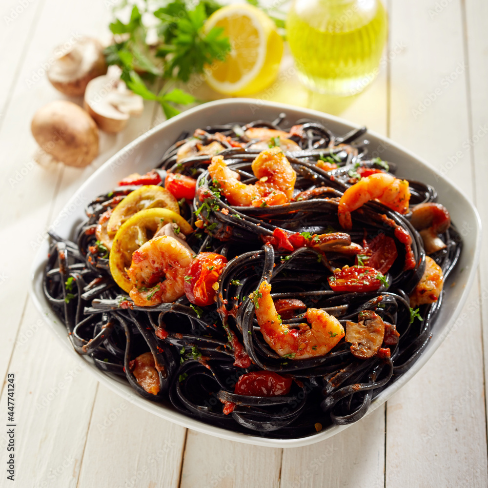 Foto de Portion of delicious black pasta with shrimp and vegetables do ...