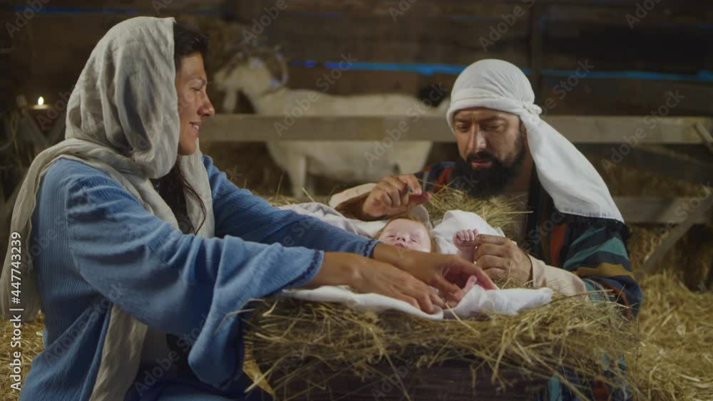 Mary and Joseph taking care of baby Jesus in inn stable nativity Stock ...