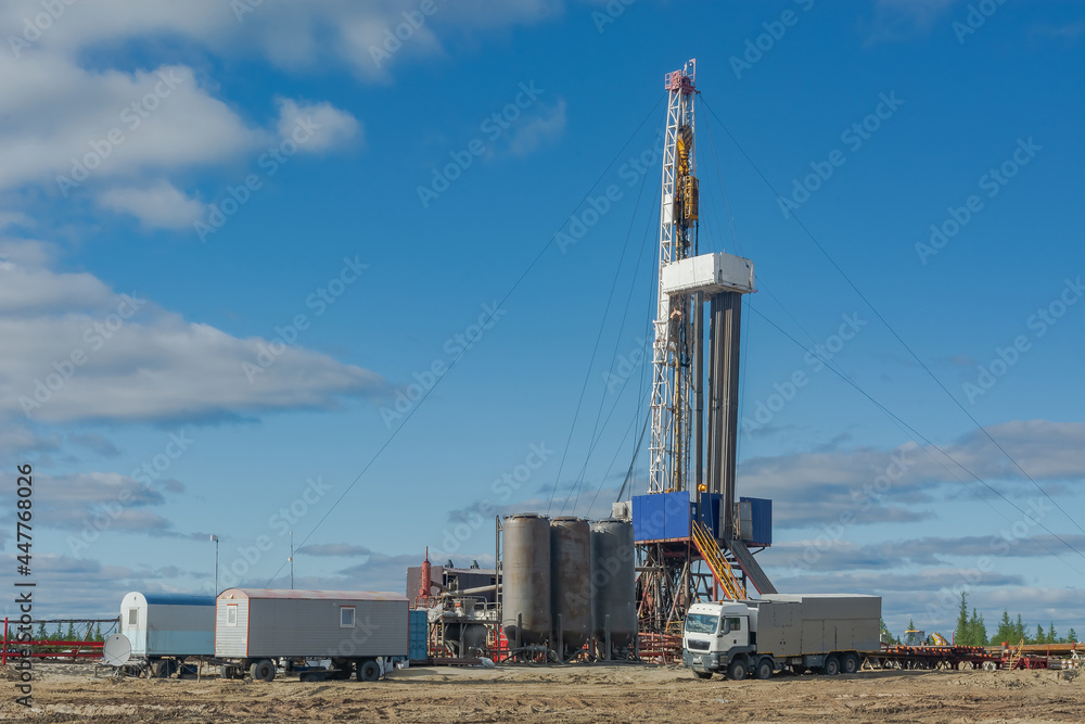 The drilling rig is included in the landscape of the oil and gas field ...