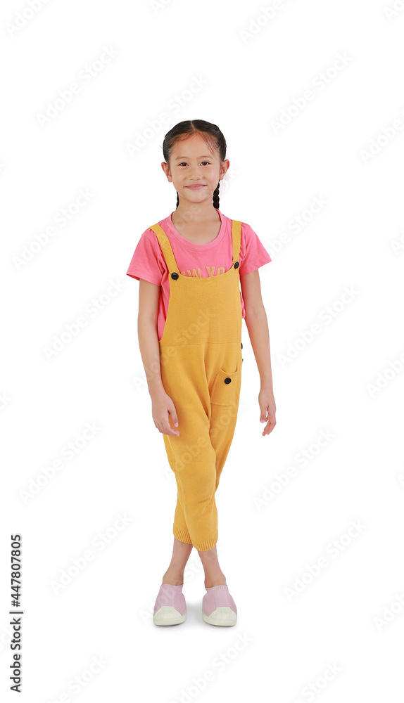 Smiling Asian little girl child crossed legs standing and looking ...