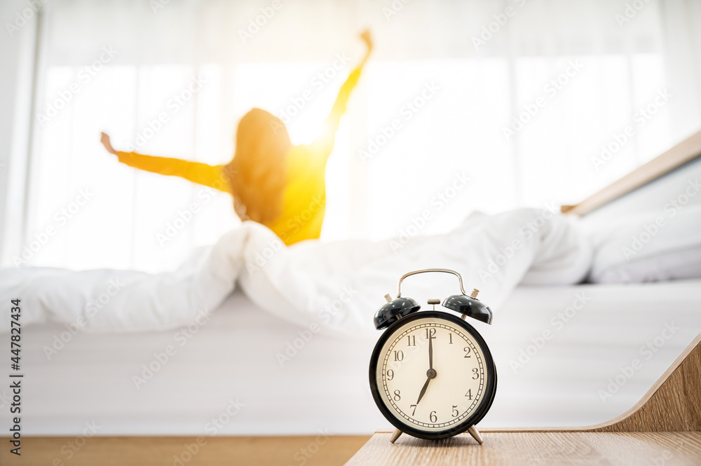 Good morning new day. Alarm clock wake up and woman sitting body ...