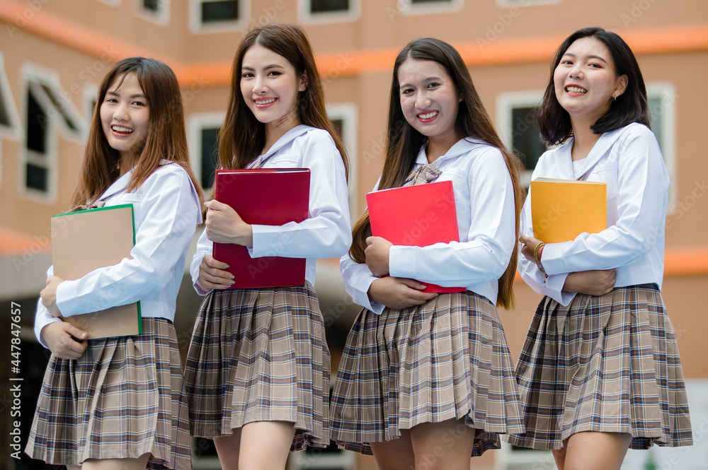 Group of four young attractive asian female high school students in ...