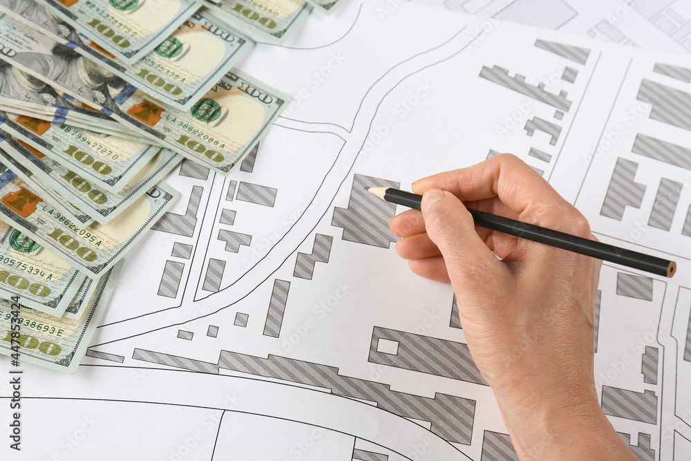 Cartographer with money drawing cadastral map, closeup Stock Photo ...