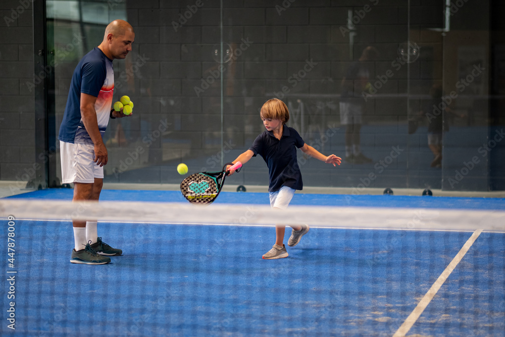 Monitor teaching padel class to child, his student - Trainer teaches ...