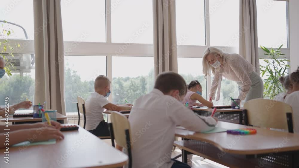Student in protective mask studying at school during corona virus ...