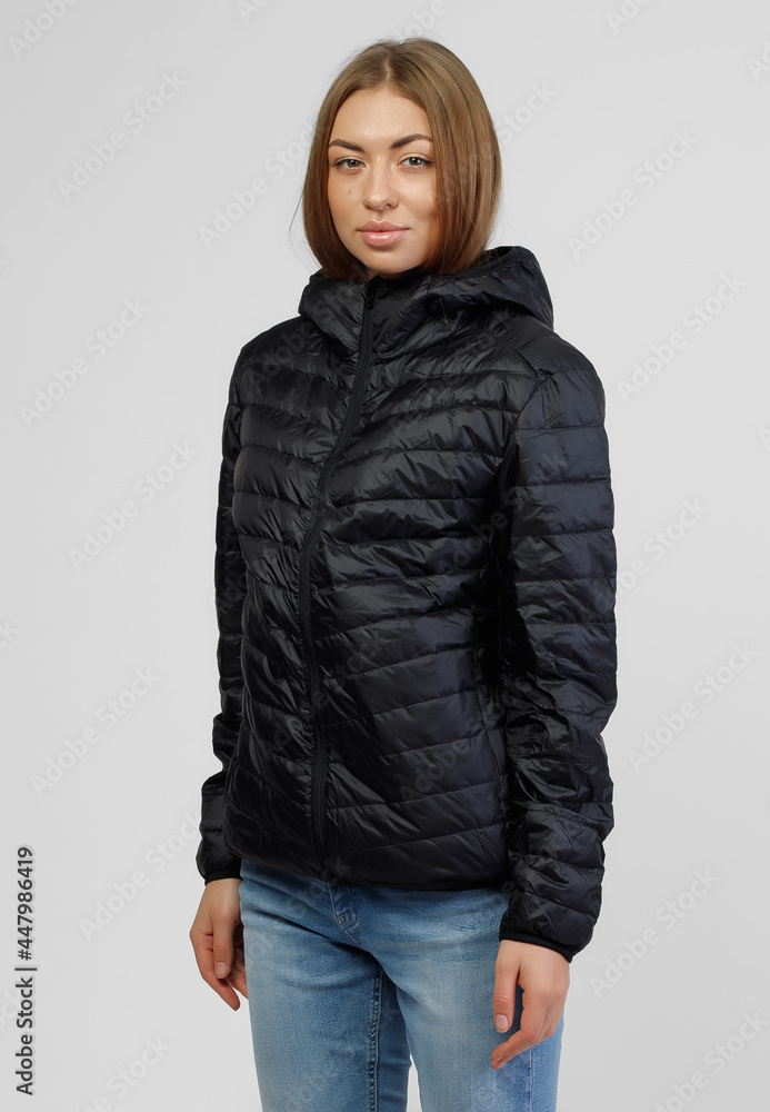 Young female model posing in black down jacket isolated on white ...