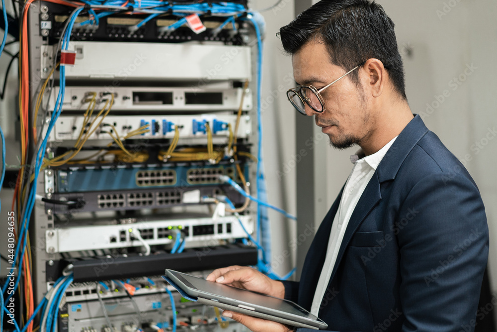 Stock photo of a young network technician holding tablet working to ...