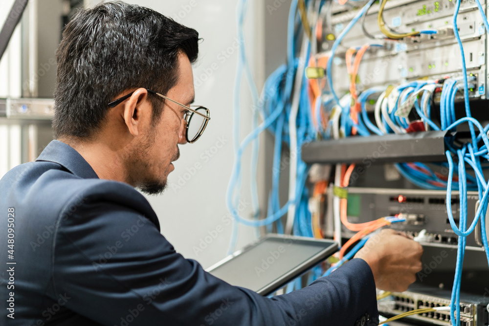 Stock photo of a young network technician holding tablet working to ...