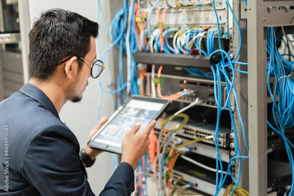 Stock photo of a young network technician holding tablet working to ...