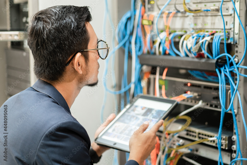 Stock photo of a young network technician holding tablet working to ...