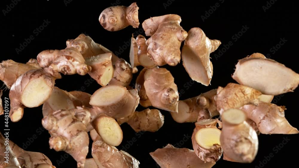 Vidéo Stock Super slow motion of cut ginger roots flying in the air on ...