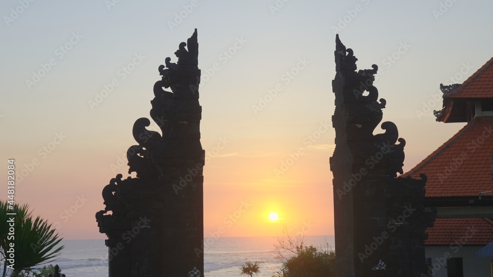 A beautiful bright tropical sunset through the Balinese religious ...