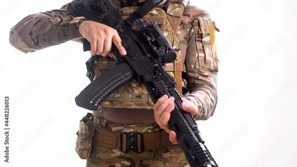 Stockvideo Man in combat camouflage and body armor attaches an ...