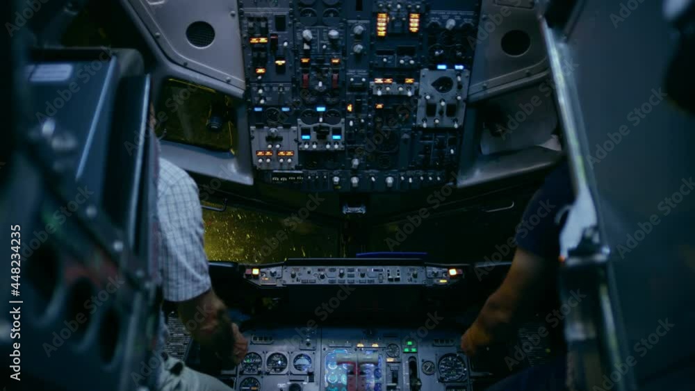 Two caucasian male pilots in the cockpit or flight deck of a passenger ...